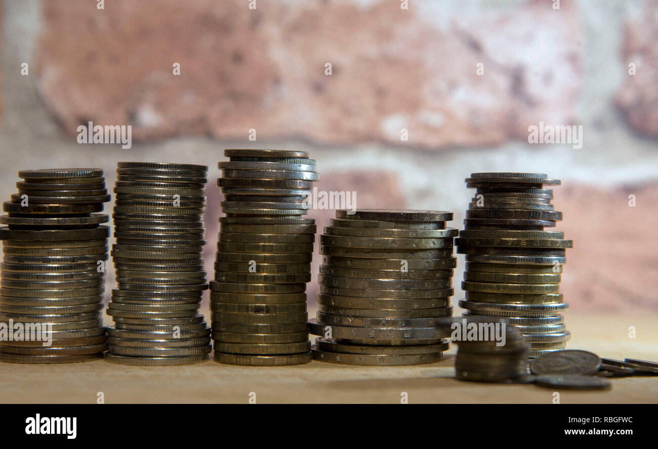 Stacks of coins and a vintage brick wall reverse Stock Photo - Alamy