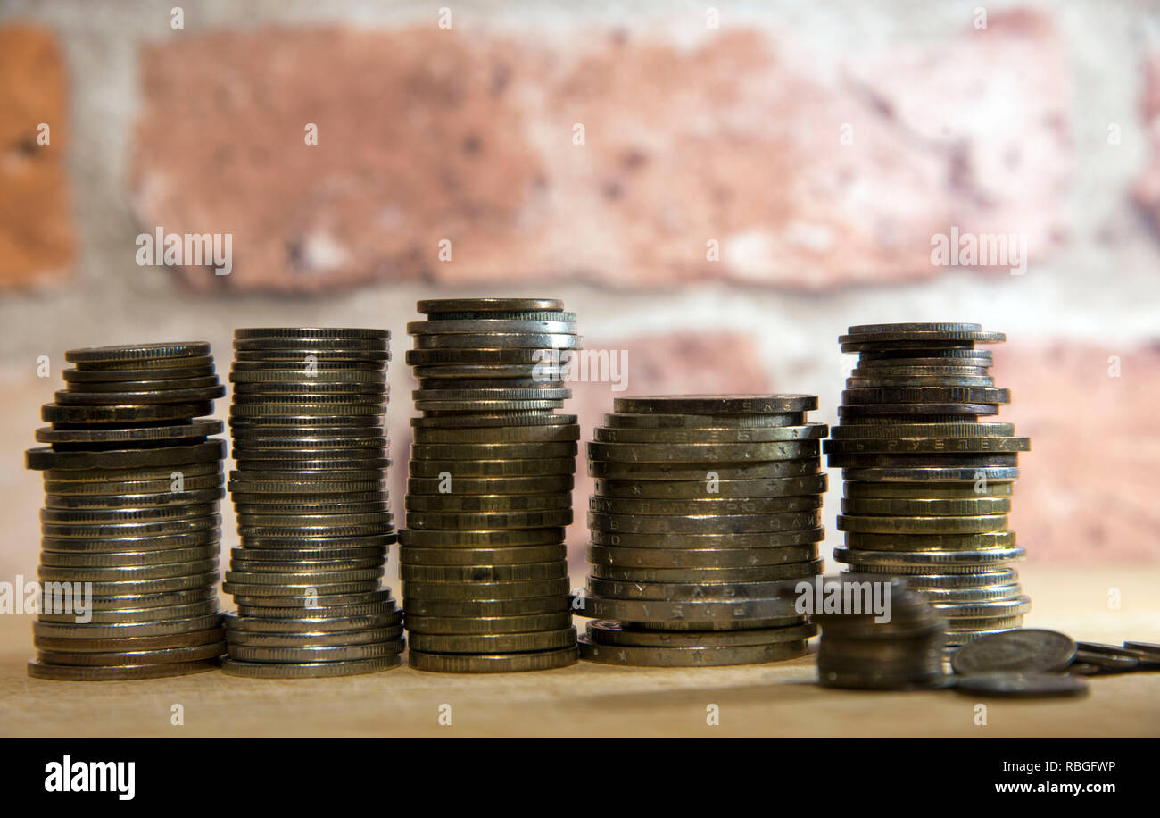 Stacks of coins and a vintage brick wall reverse Stock Photo - Alamy