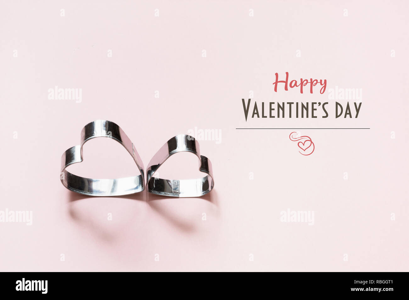 Valentine's card. Creative couple heart cookie cutters on pastel pink ...