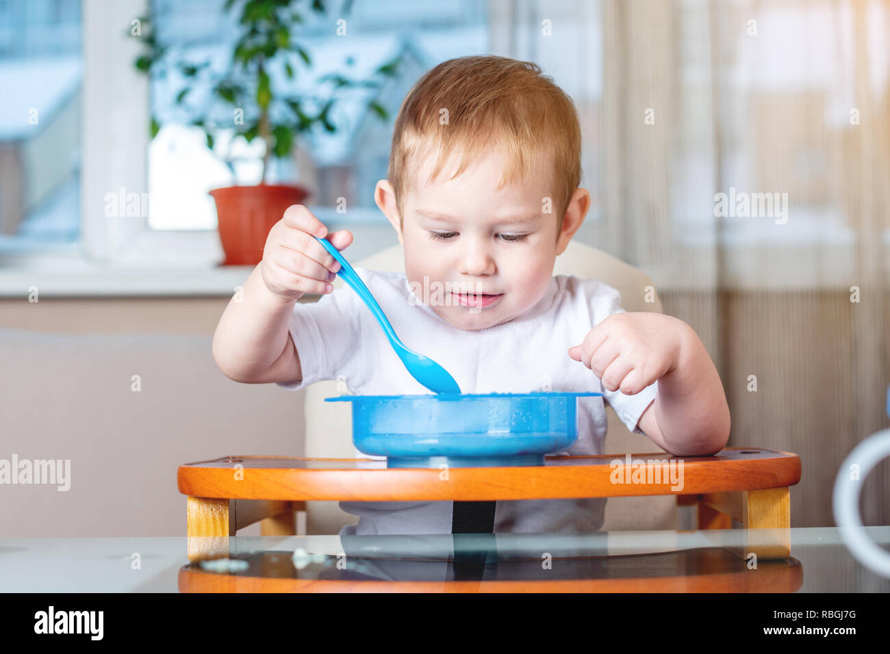 Child learning to eat with spoon hi-res stock photography and images ...