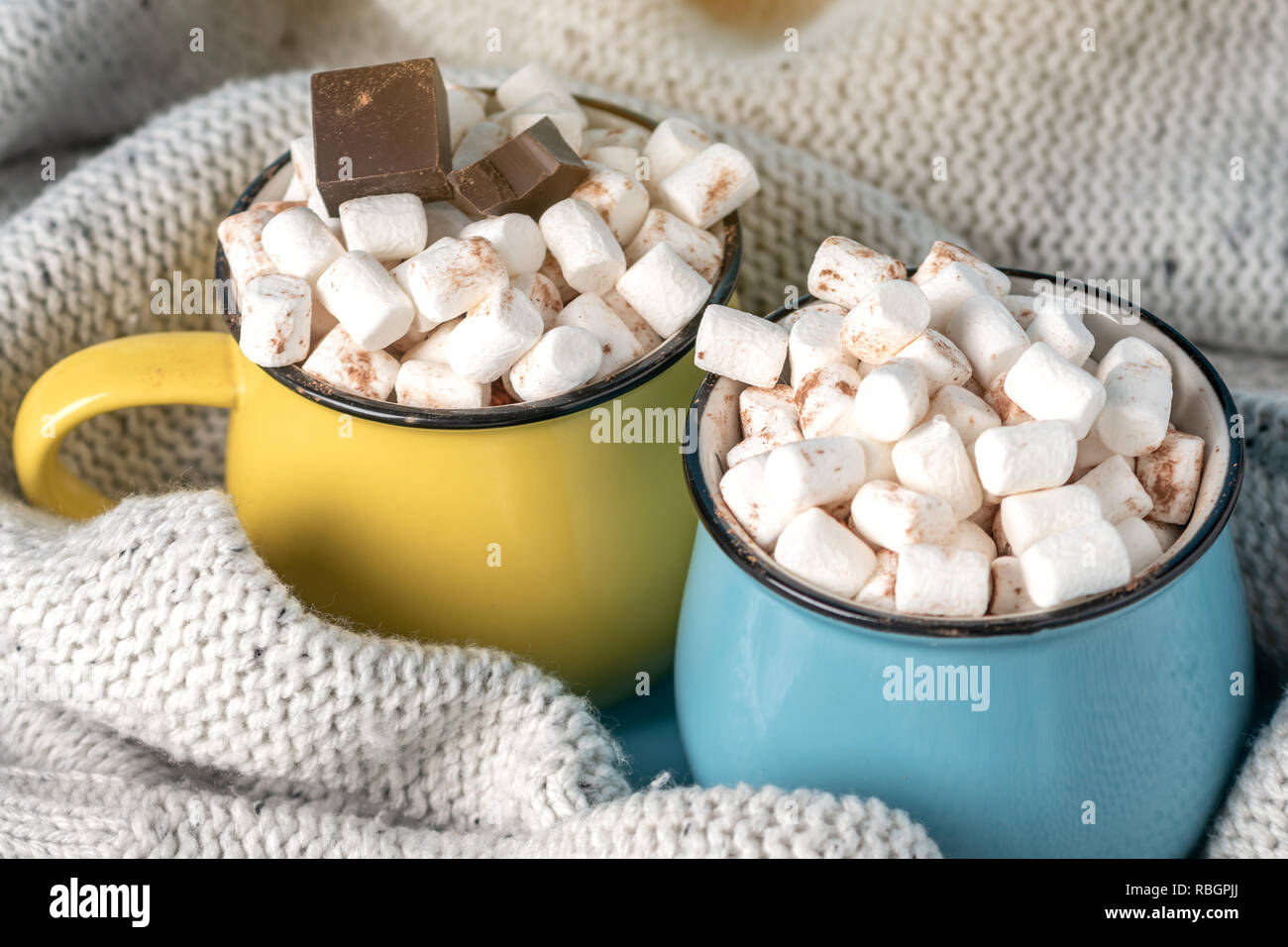 Mugs of hot chocolate with marshmallows on top on a blue background ...