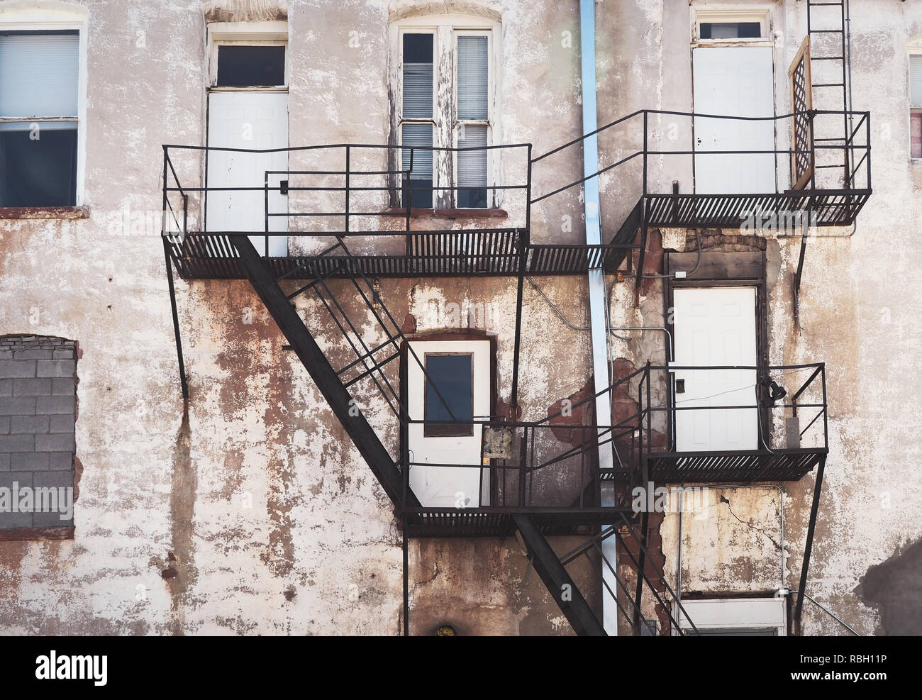 rundown building with fire ladders and many doors, interesting wall ...