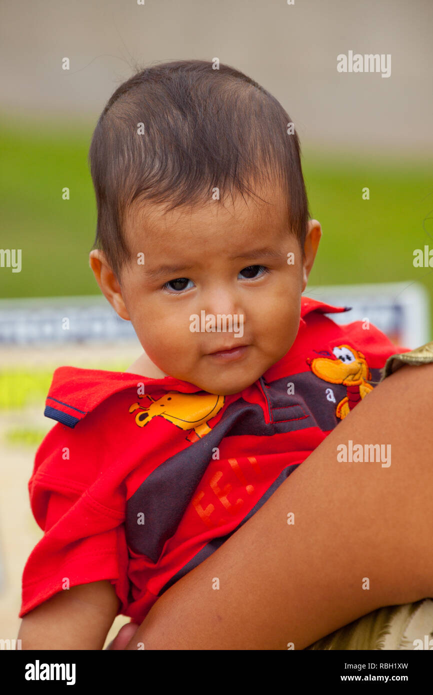 A smaal child in its mother's hug in the zoo of Lima in Peru Stock ...