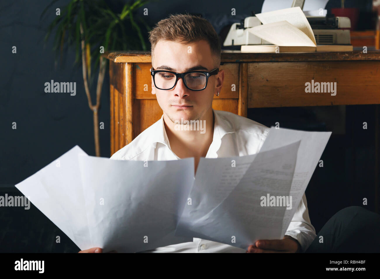 Handsome writer man wearing glasses and white shirt sitting on the ...