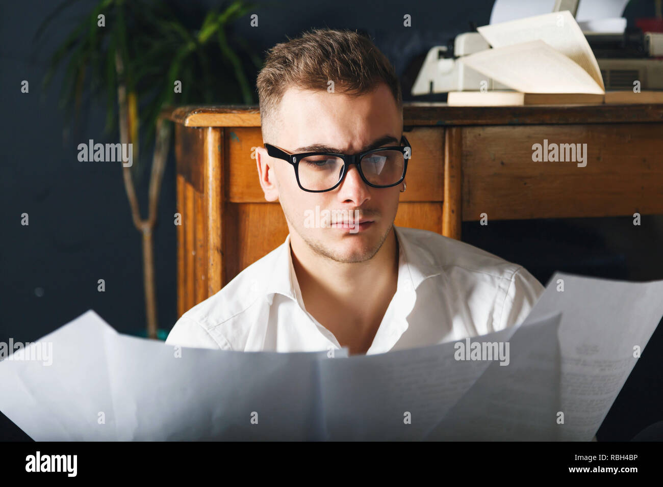 Handsome writer man wearing glasses and white shirt sitting on the ...