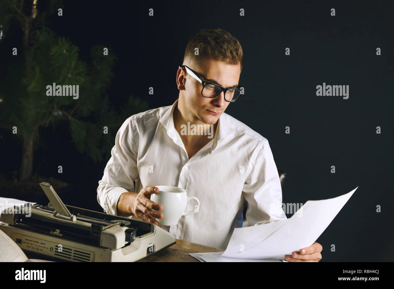 Handsome writer man wearing glasses and white shirt sitting at the ...