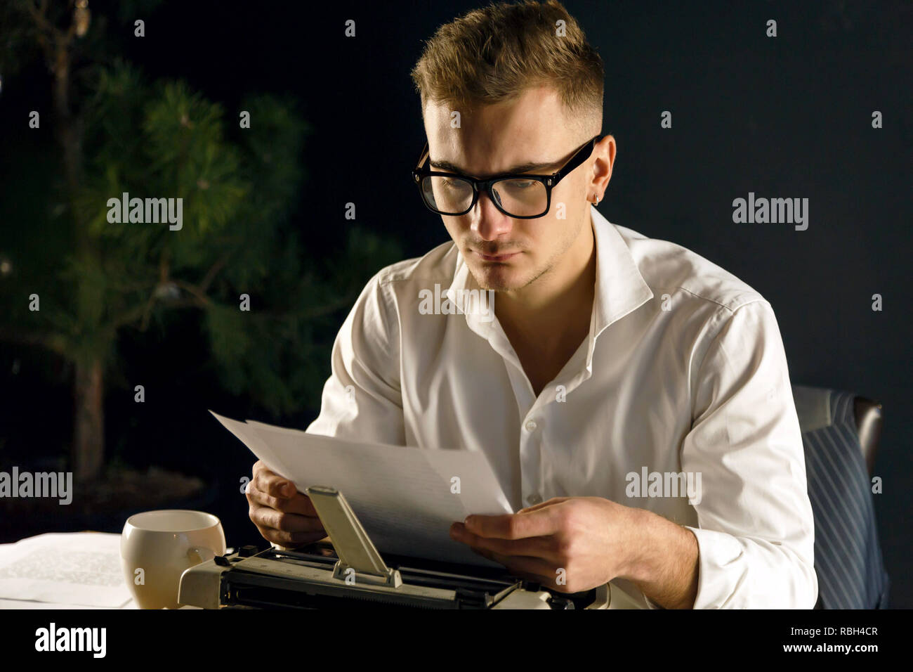 Handsome writer man wearing glasses and white shirt sitting at the ...