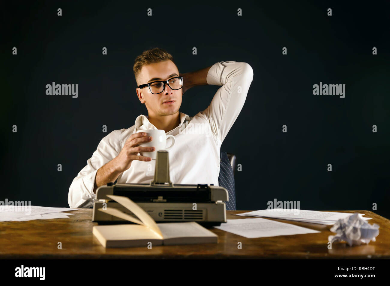 Handsome writer man wearing glasses and white shirt sitting at the ...