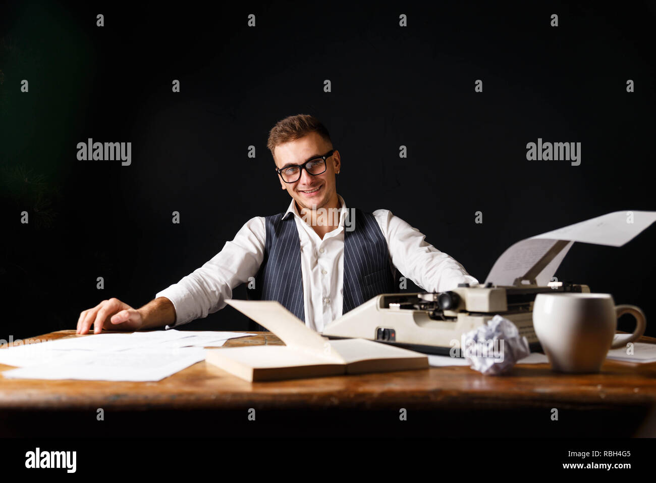 Book writer wearing glasses and white shirt sitting and smiling at the ...