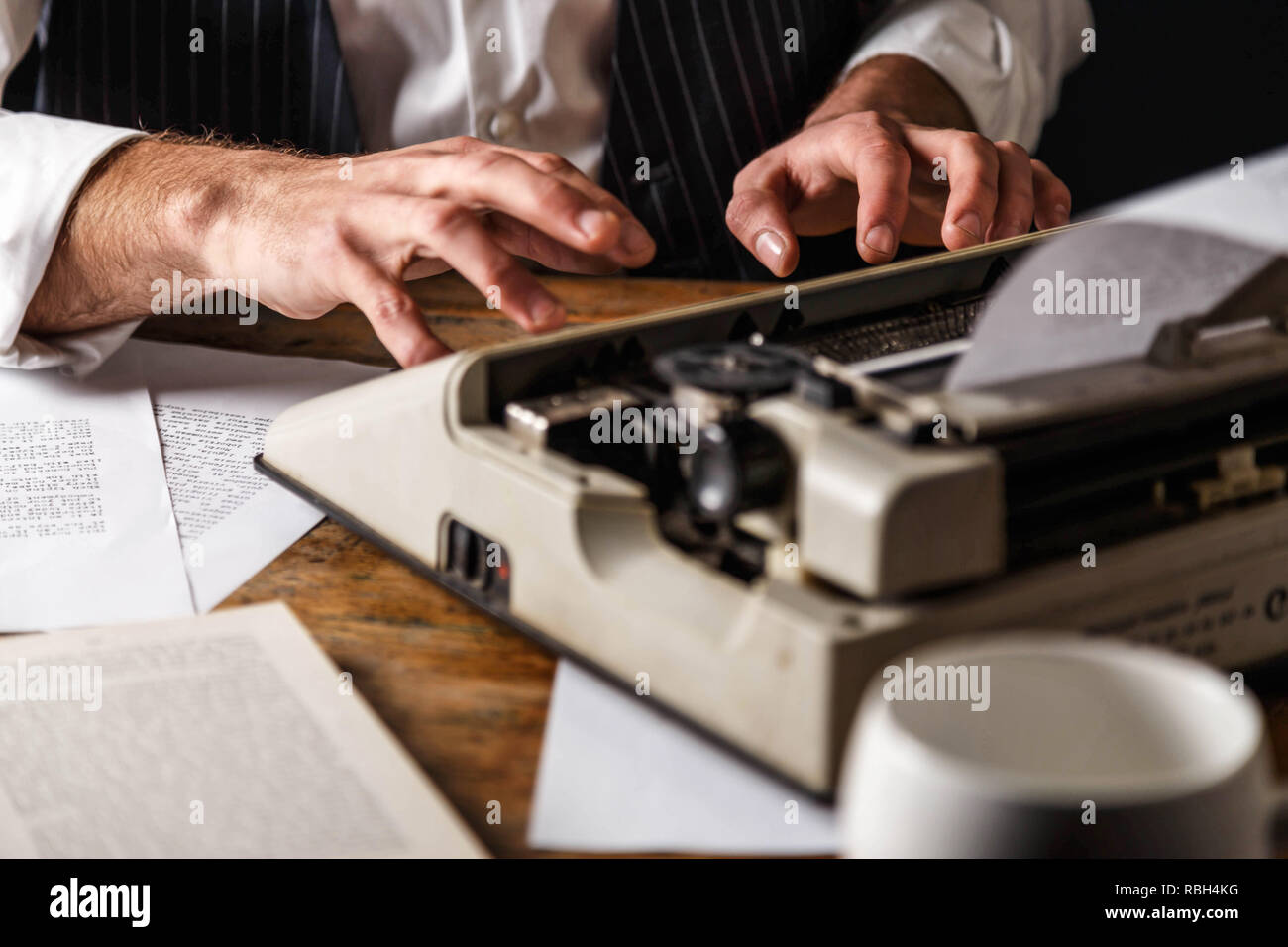 Young man's hands typing new book on an antique vintage typewriter ...