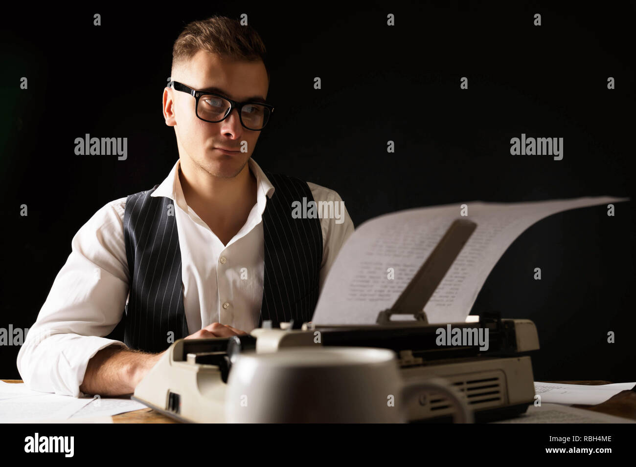 Book writer wearing white shirt sitting at the his workplace and using ...