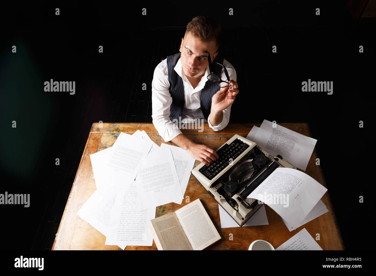 Book writer wearing white shirt sitting at the his workplace and ...