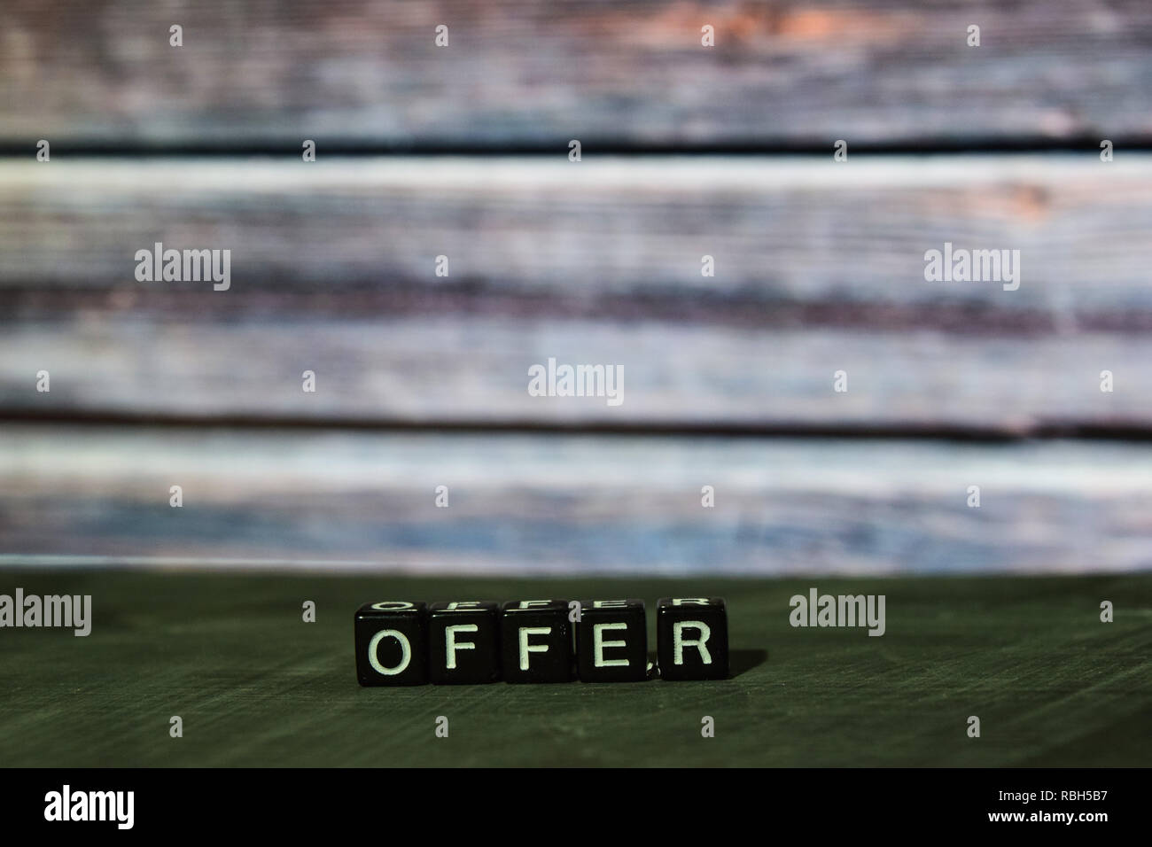 Offer on wooden blocks. Cross processed image with bokeh background ...