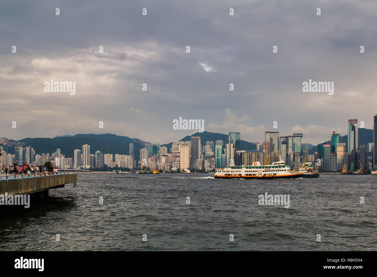 Hong Kong skyline cityscape downtown skyscrapers over Victoria Harbour with tourist ferry boat ...