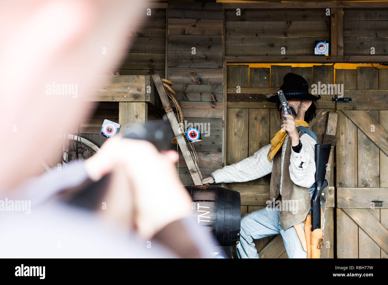 Blurry Man at Foreground Aiming at Clear Ranch Themed Items with Bulls ...