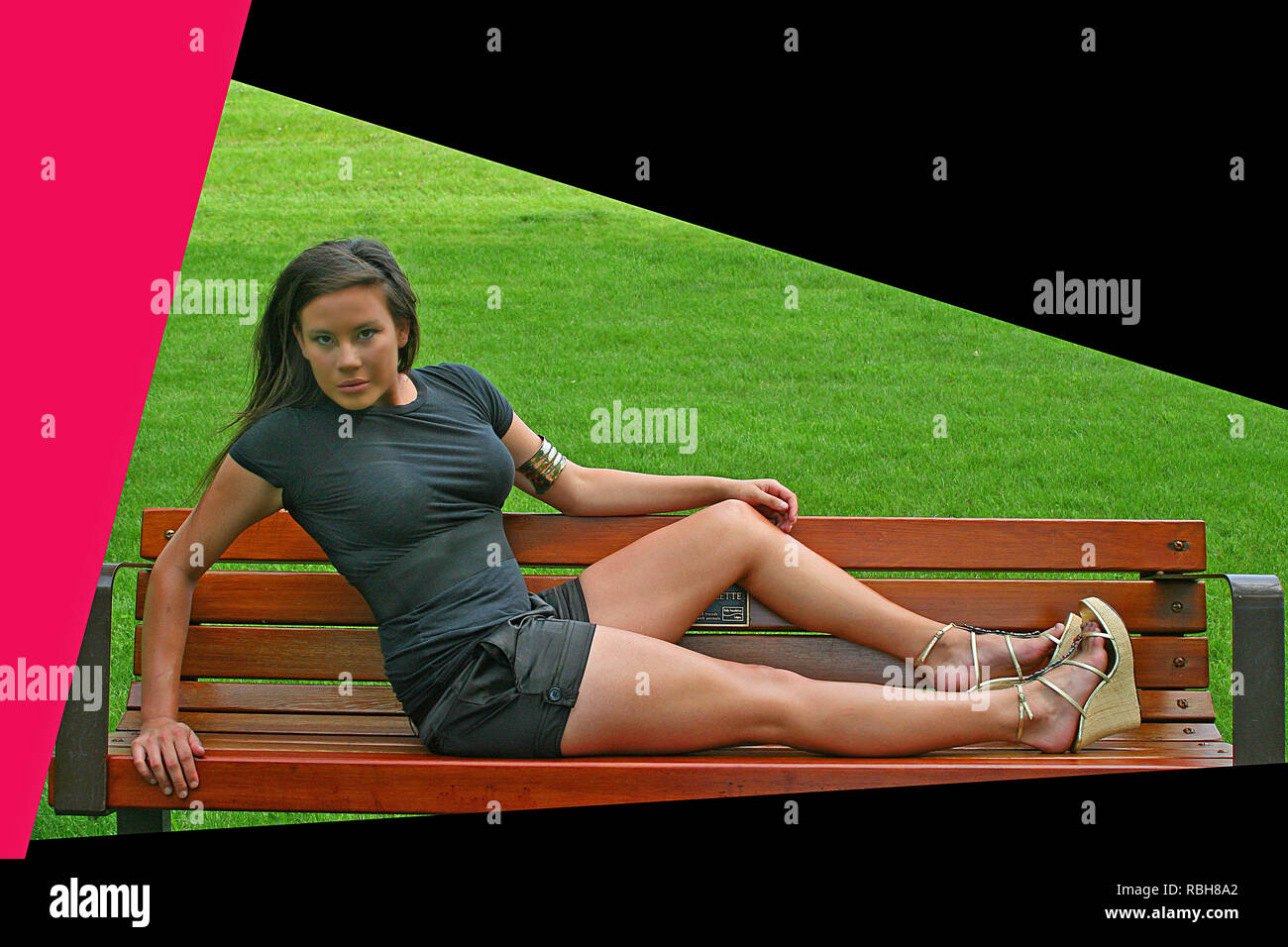 Beautiful brunette girl sitting on a park bench Stock Photo - Alamy