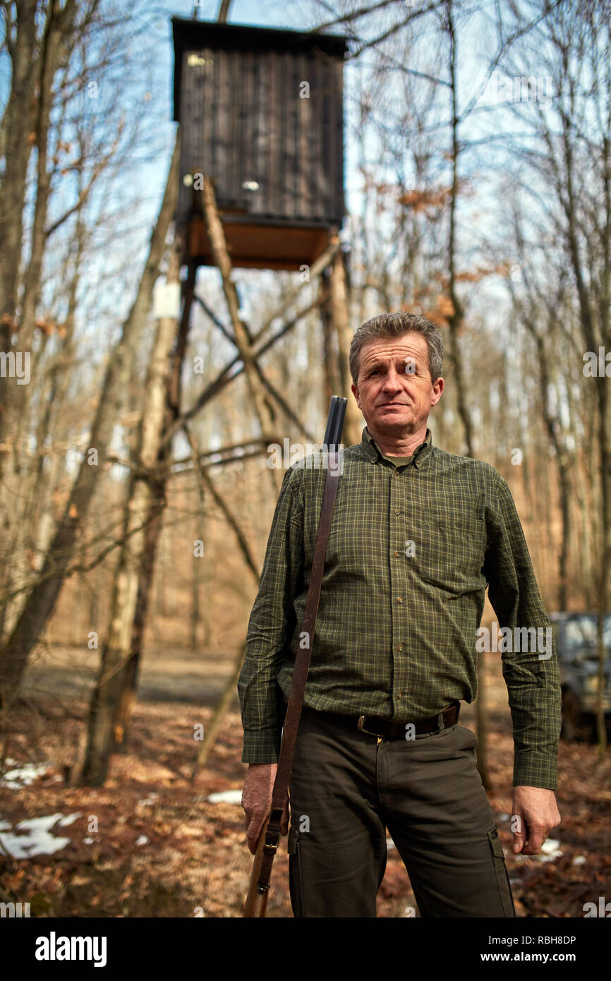Game ranger with gun at the feeding spot for wild animals Stock Photo ...
