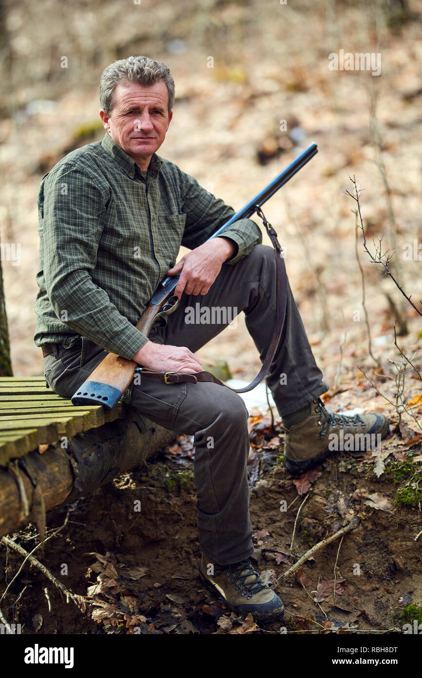 Game ranger with gun at the feeding spot for wild animals Stock Photo ...