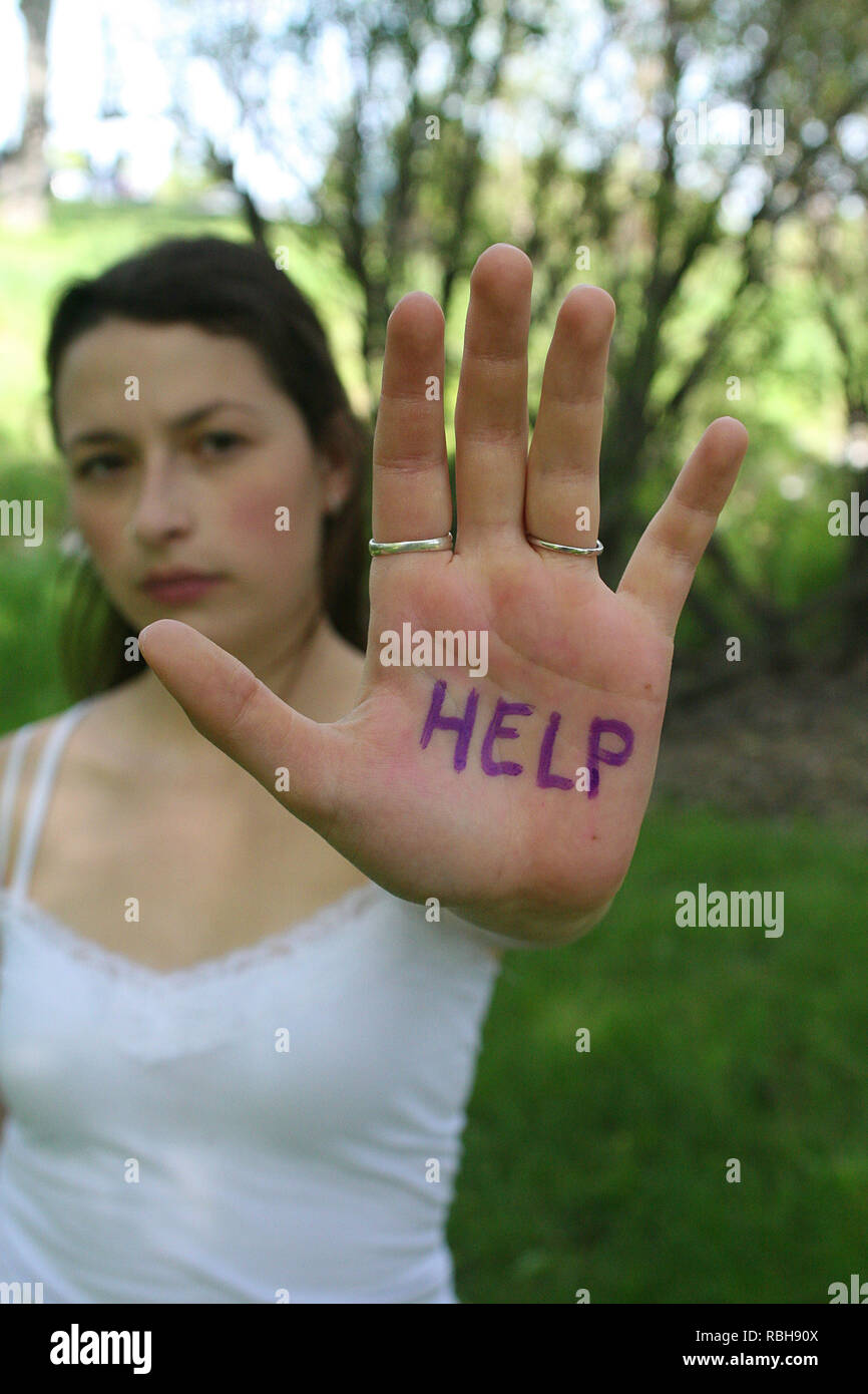 Brunette girl in a park outdoors on a sunny day giving hand signals ...