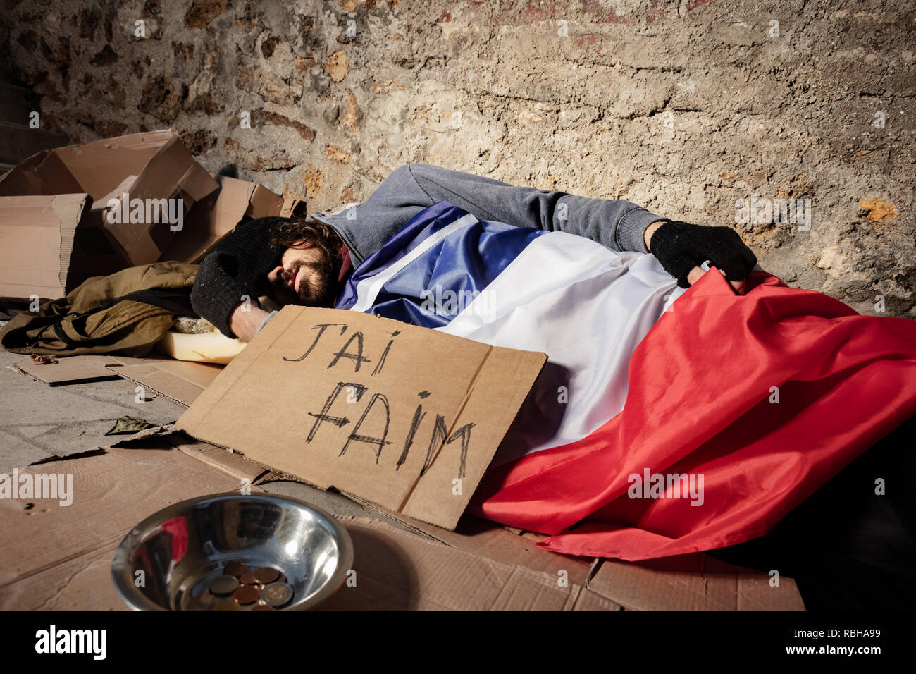 Homeless man sleeping outside under French flag Stock Photo - Alamy