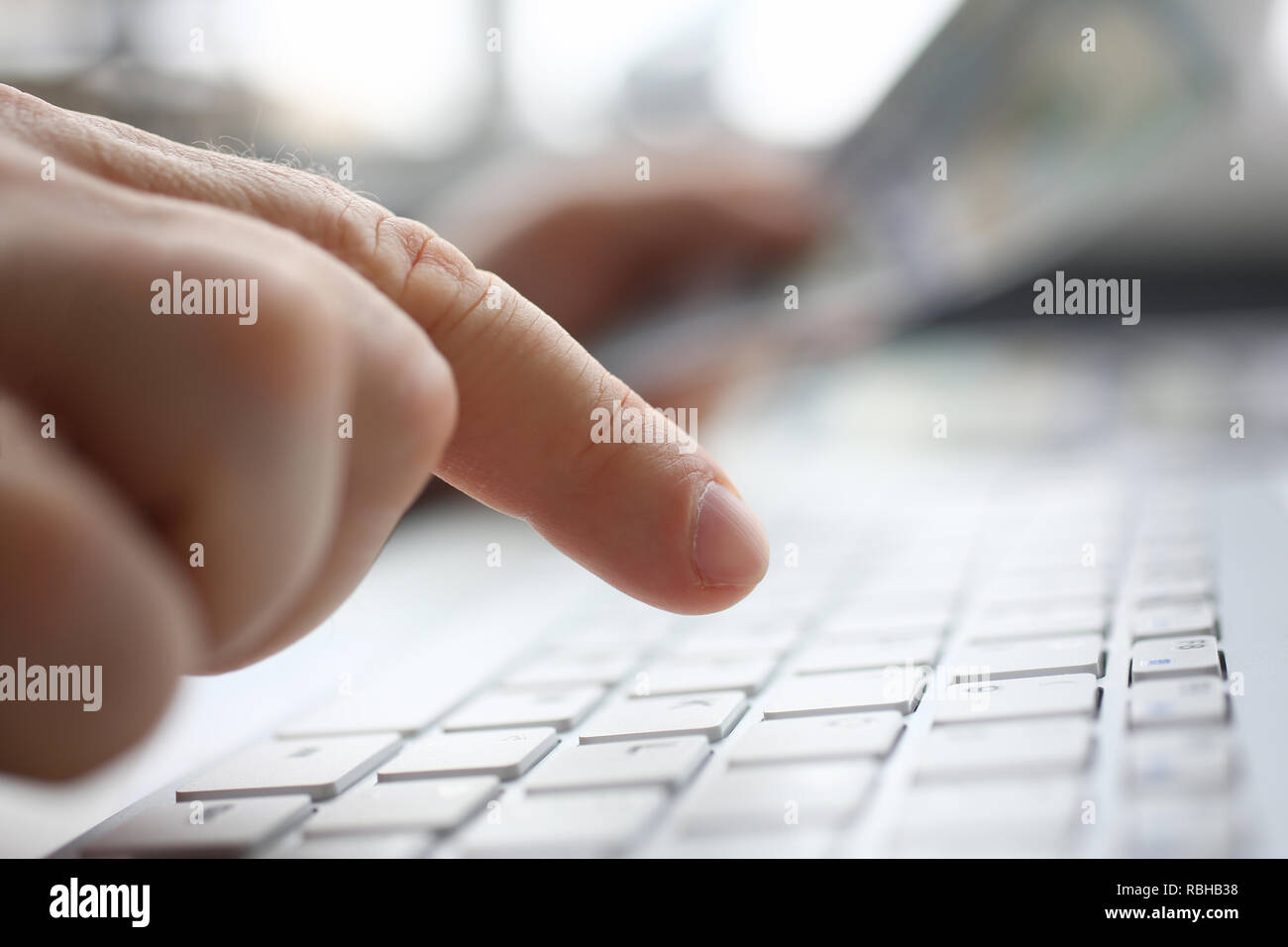 Male arms hold credit card press buttons Stock Photo - Alamy