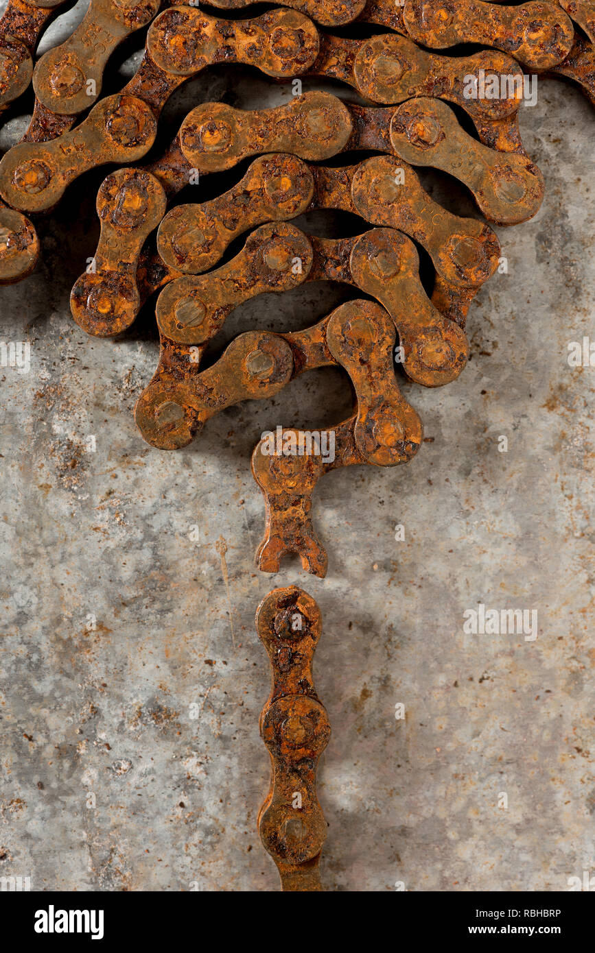 Weakest link in a strong steel rusty roller chain is broken snapped ...