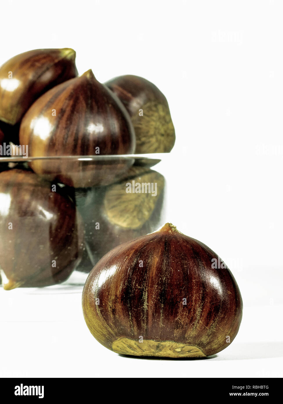 group of fresh chestnuts in glass container on white background Stock ...
