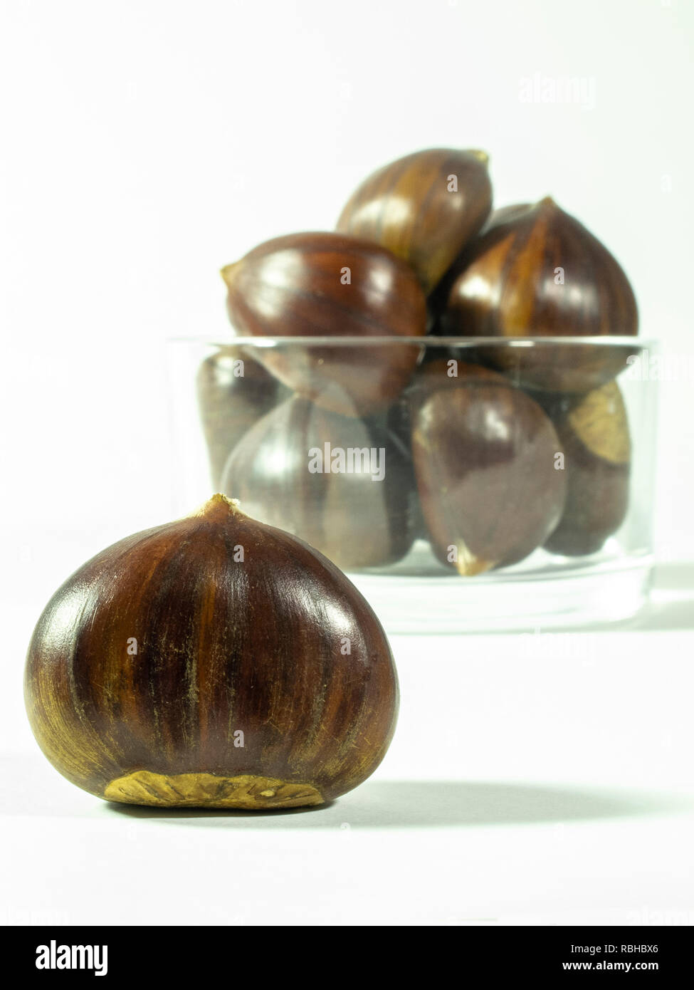 group of fresh chestnuts in glass container on white background Stock ...