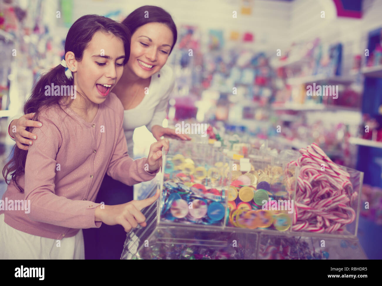Happy cheerful smiling woman with emotional daughter choosing candies ...