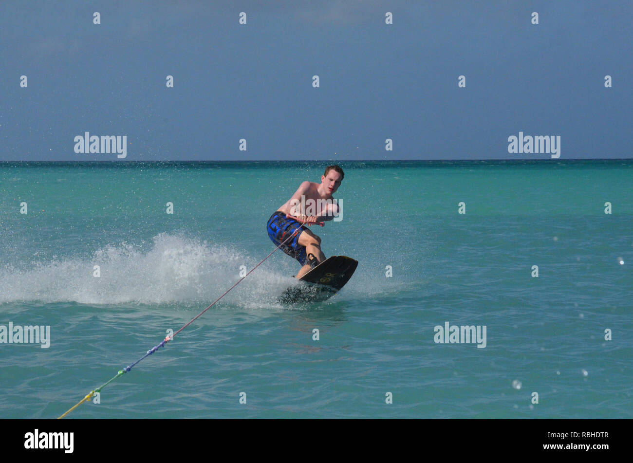 Wakeboarder creating a small wake in tropical Carribean waters Stock ...