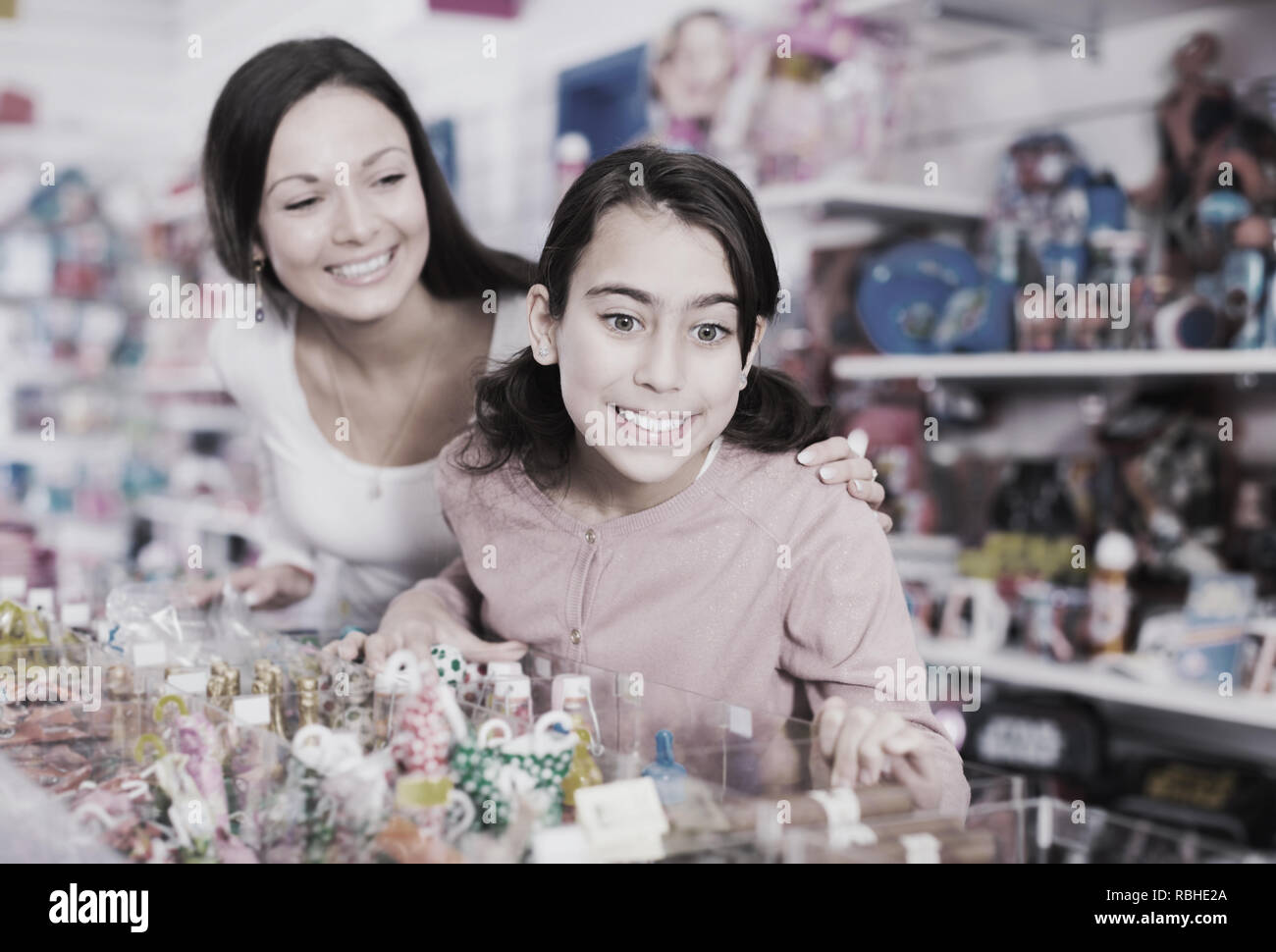 Female with smiling girl choosing tasty candies in the candy shop Stock ...