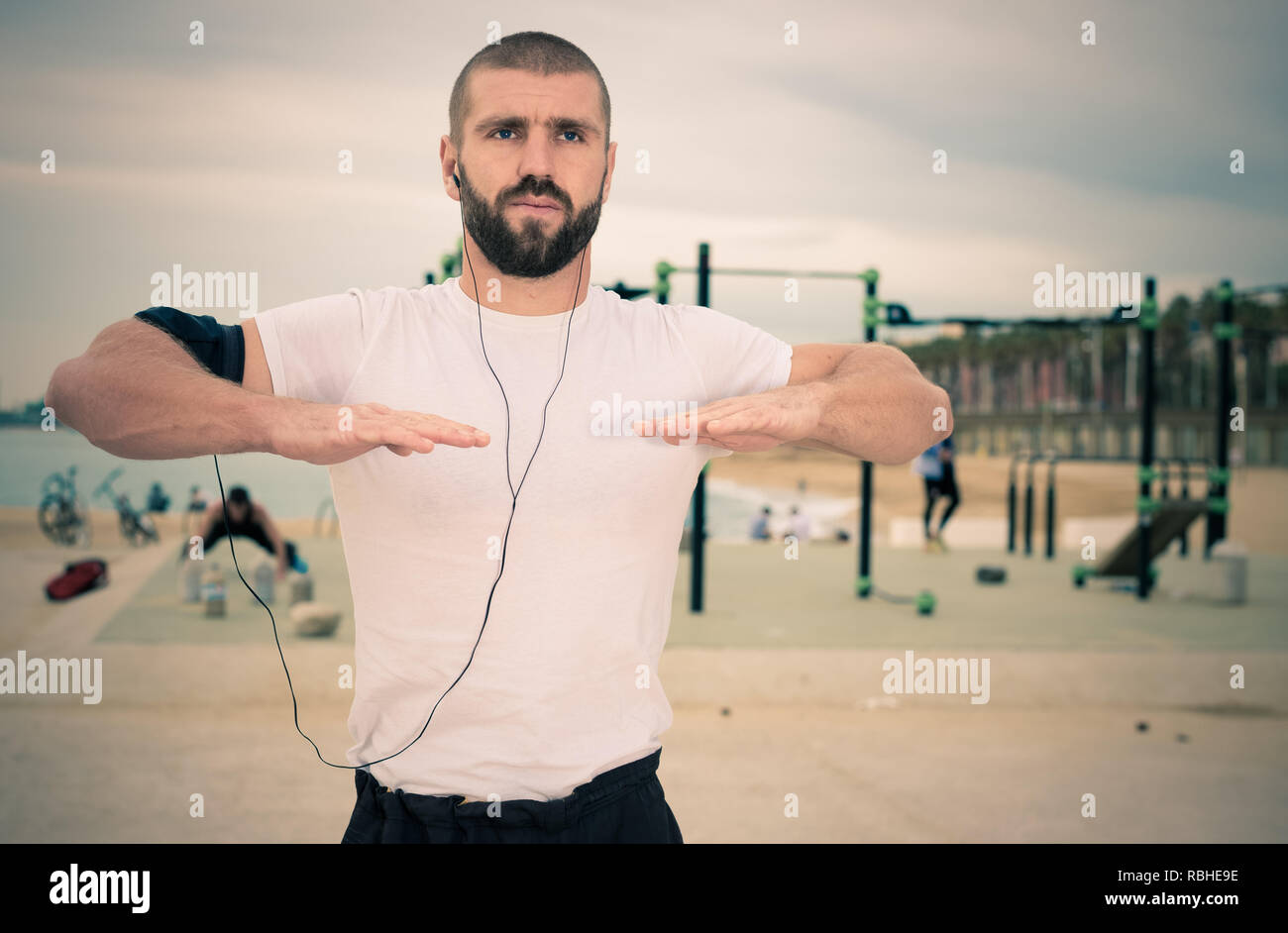 Athletic male performs warm-up exercises before training Stock Photo ...