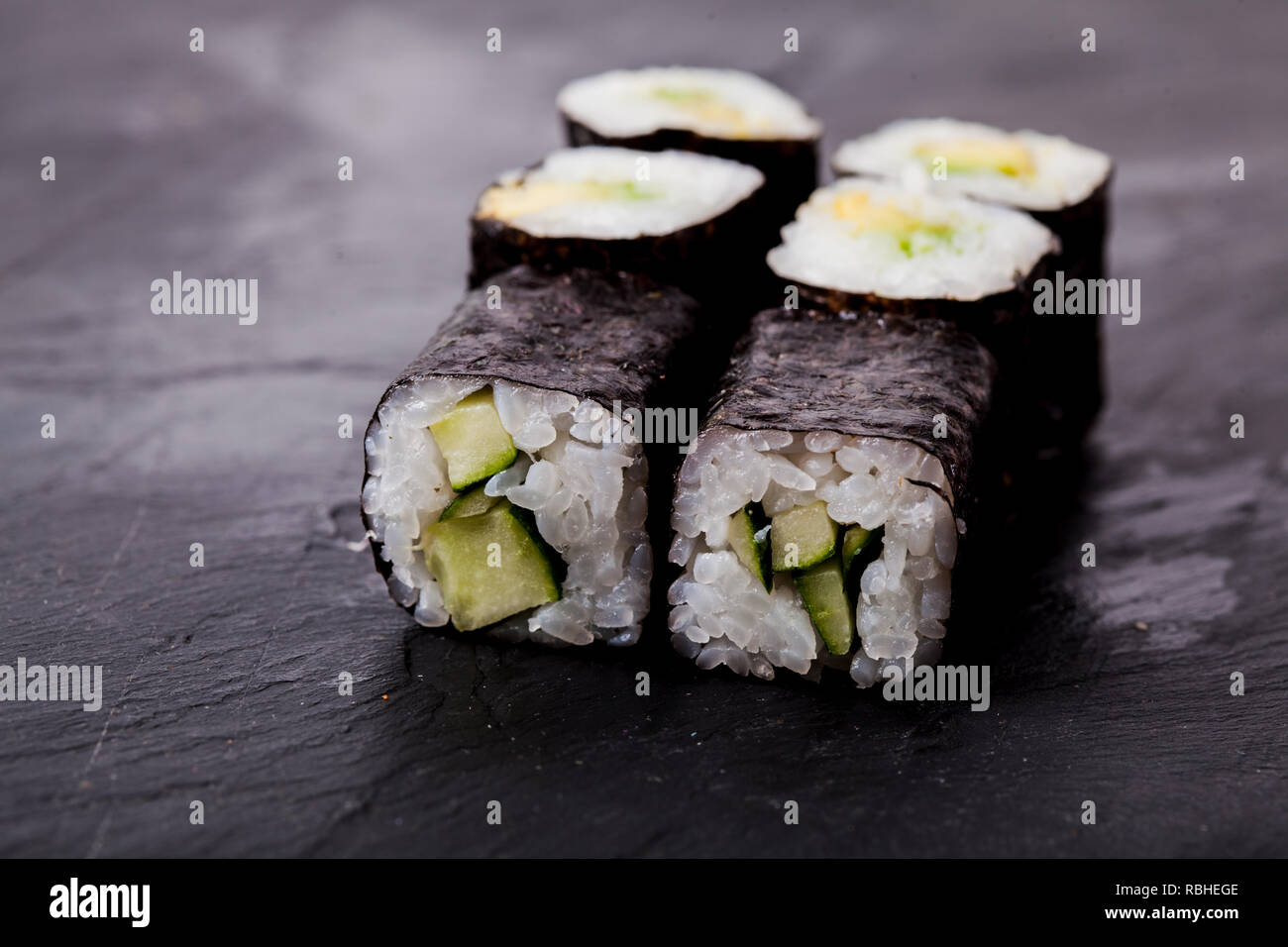 Cucumber sushi roll on black slate board Stock Photo - Alamy