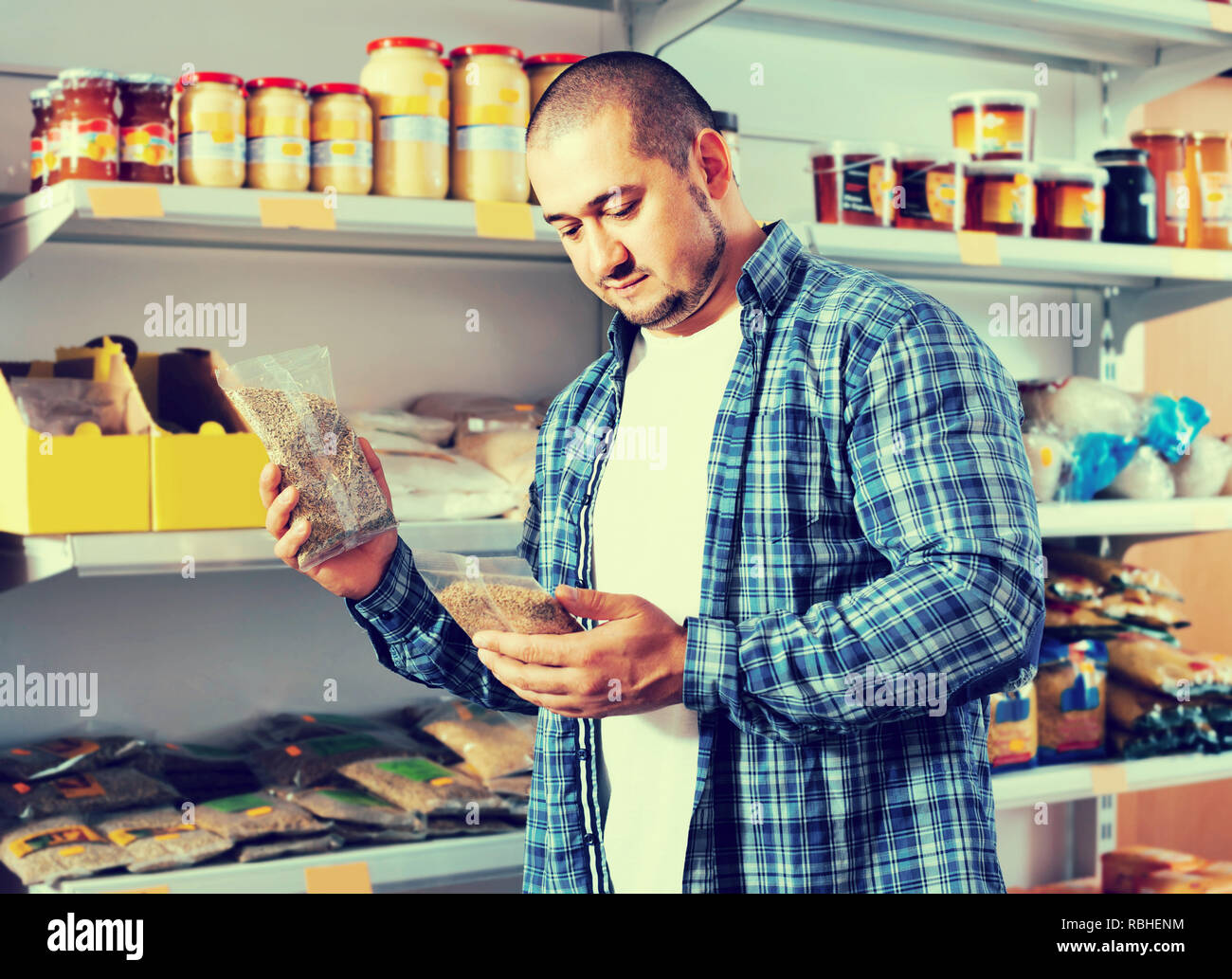 positive american male customer choosing nuts and grain in average food ...