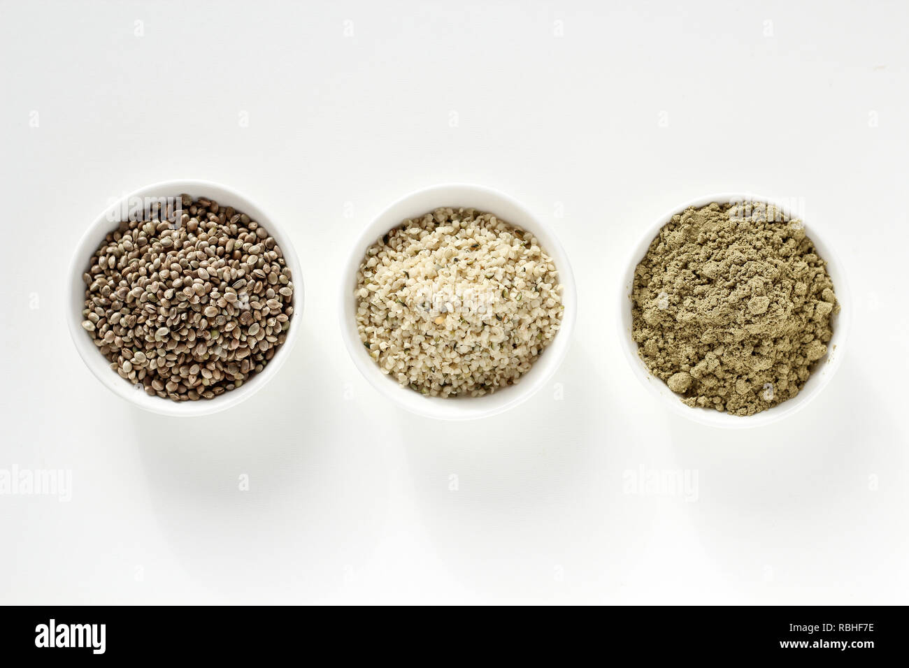 Organic hemp whole seeds, hulled seeds and protein powder in bowls on a ...