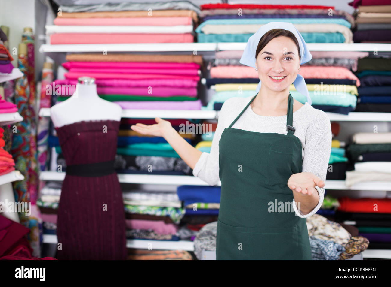 Female shop assistant demonstrating assortment at drapery shop Stock ...