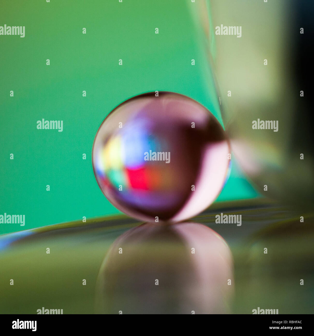 Marble ball with colorful lights on a green abstract background Stock ...