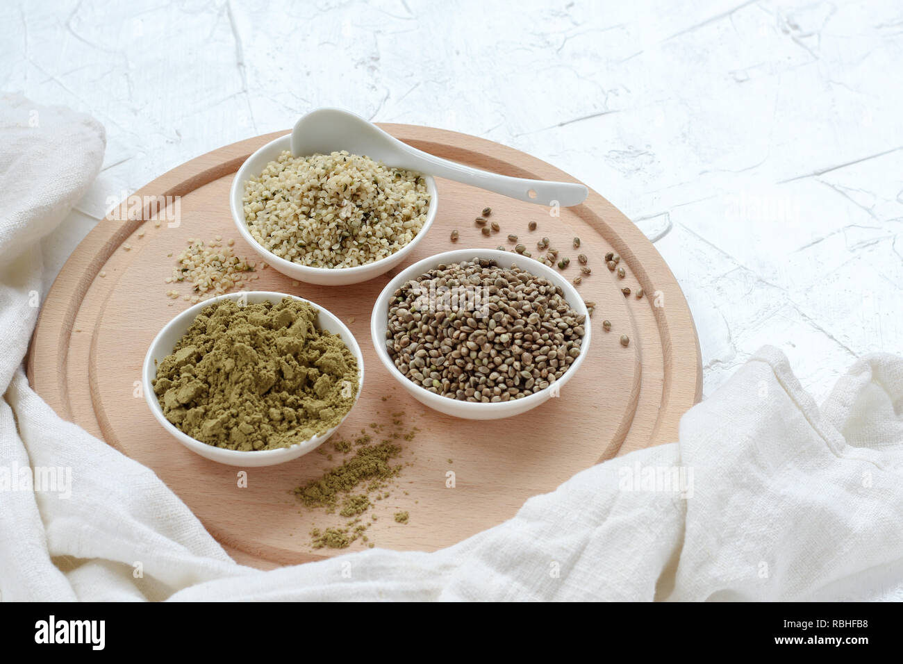 Organic hemp whole seeds, hulled seeds and protein powder in bowls on a ...