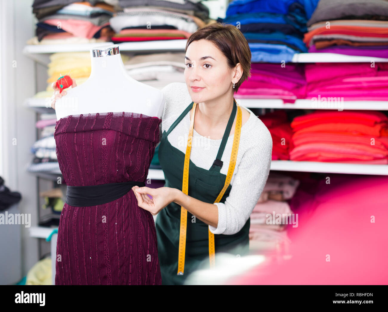 Female tailor finishing work at festive dress at studio Stock Photo - Alamy