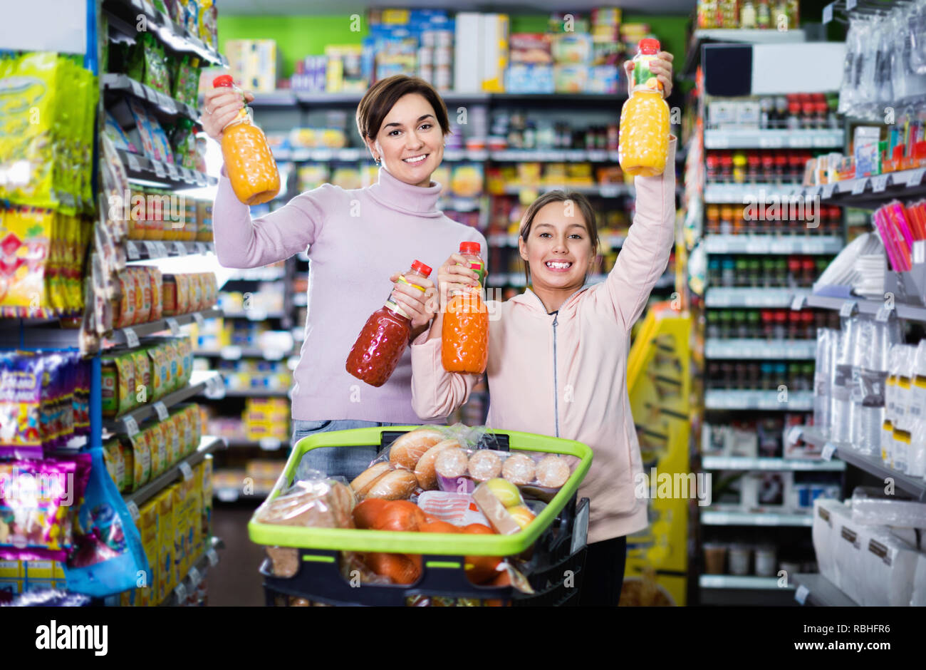 Positive smiling female shopper with teenage daughter searching for ...
