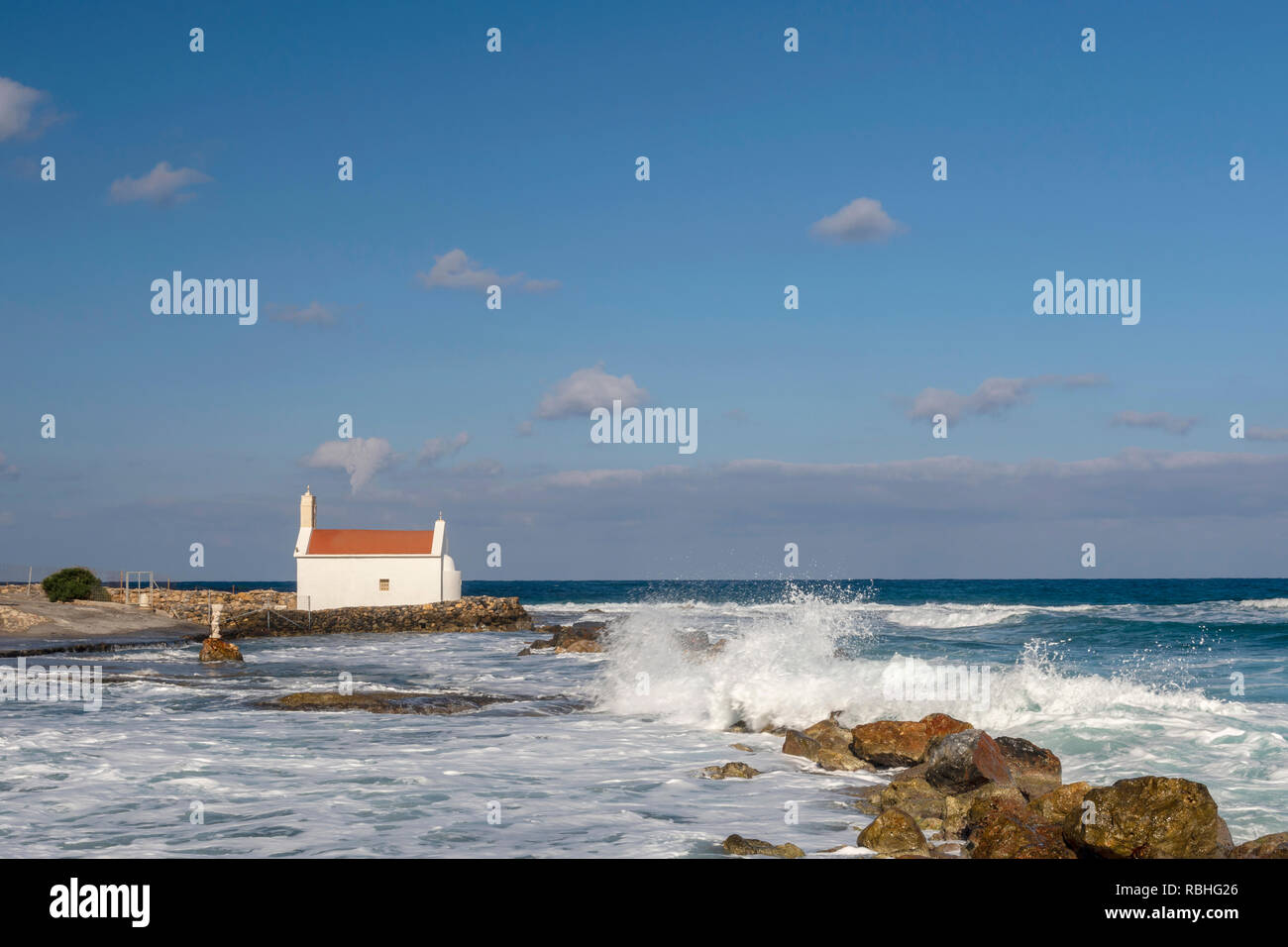 Little Sailor Church (Agios Nikolaos) with blue sea and waves and a ...