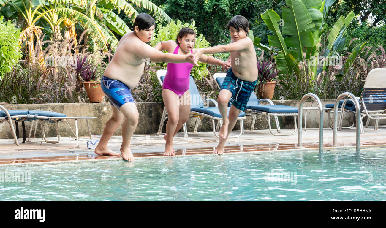 Happy Teenagers Jumping Into Outdoor Pool High Resolution Stock ...
