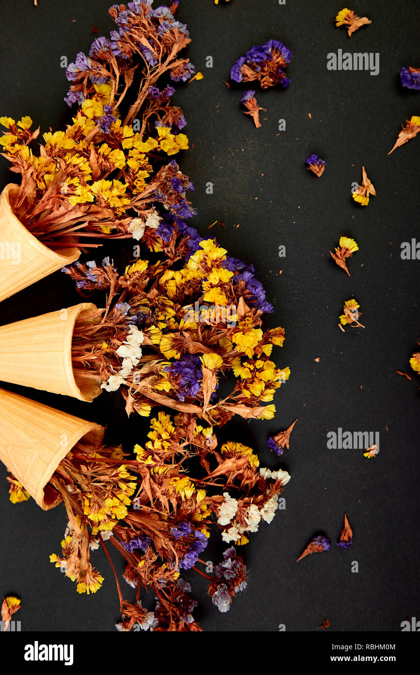 Bouquet Flowers in a waffle cone on a black background. Flat lay, top ...