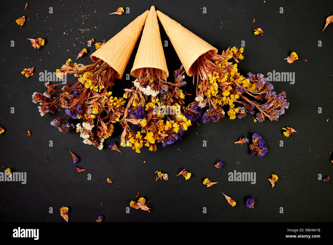 Bouquet Flowers in a waffle cone on a black background. Flat lay, top ...