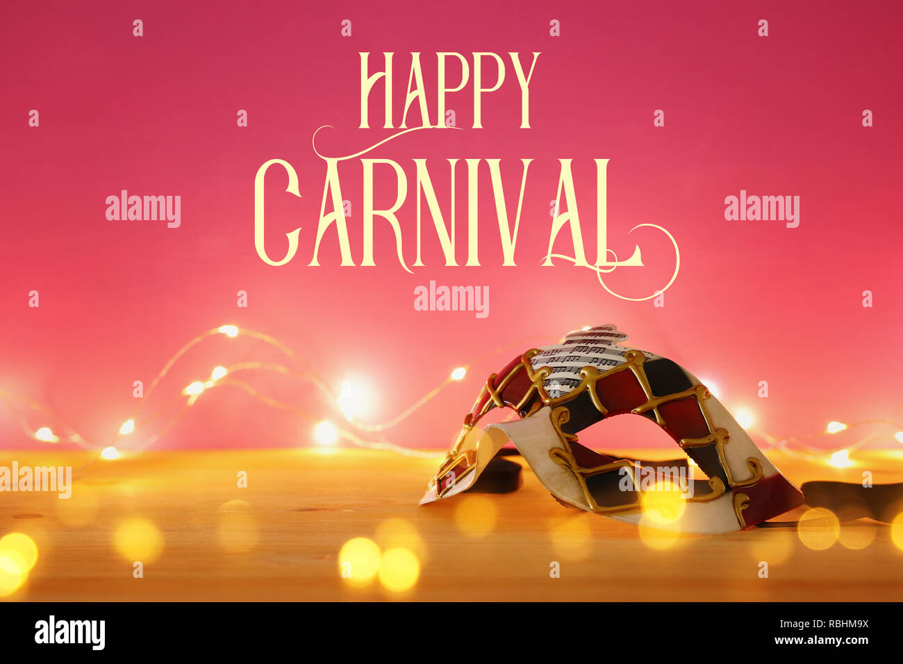 photo of elegant venetian, mardi gras mask over wooden table and pink ...