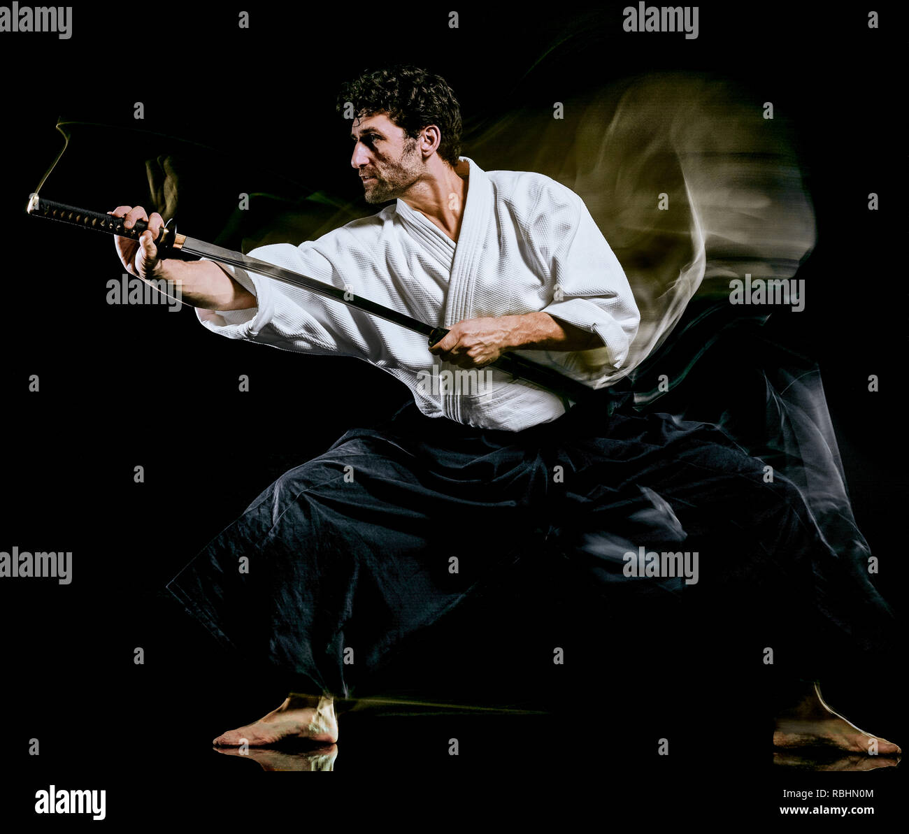 one caucasian bodoka fighters man practicing Iaido Kenjutsu studio shot ...