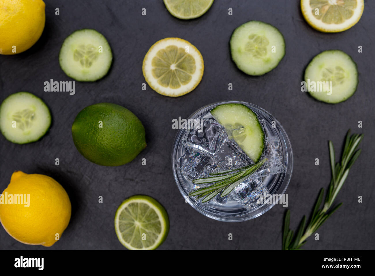 Gin tonic cocktail drink glass with ice cucumber lime lemon dark ...