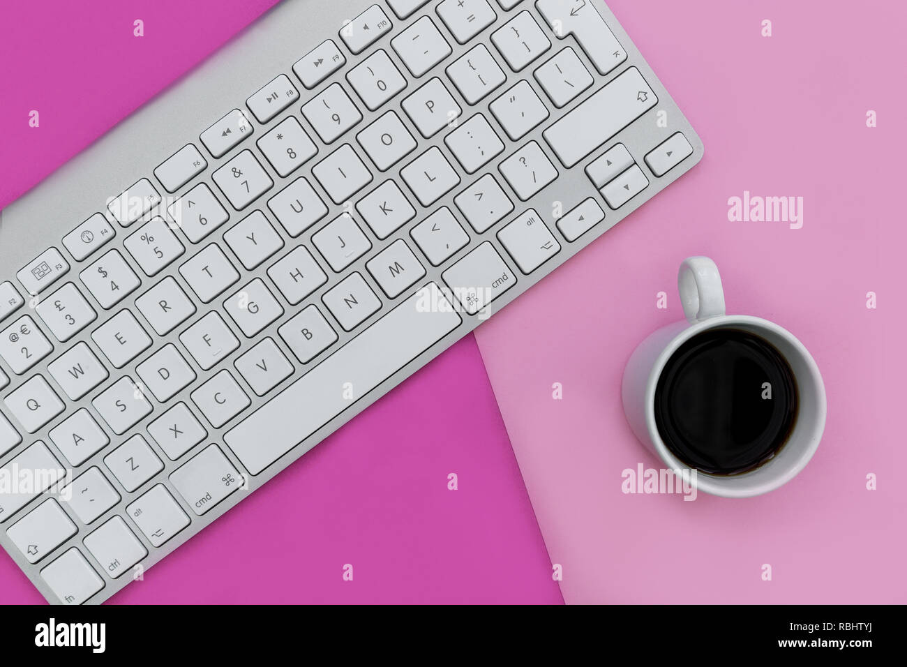 Minimal office workspace computer keyboard on bright pink color ...
