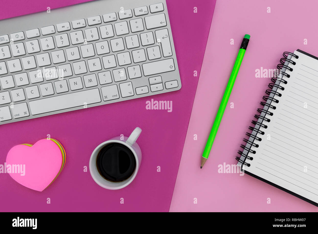 Minimal office workspace computer keyboard on bright pink color ...