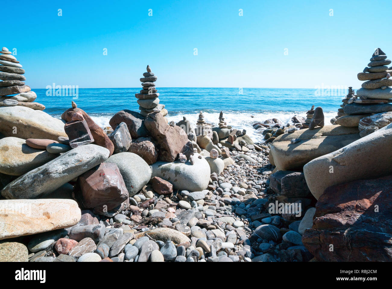 Pyramids of stones on the beach with the bright sun. Crimea. Russia ...